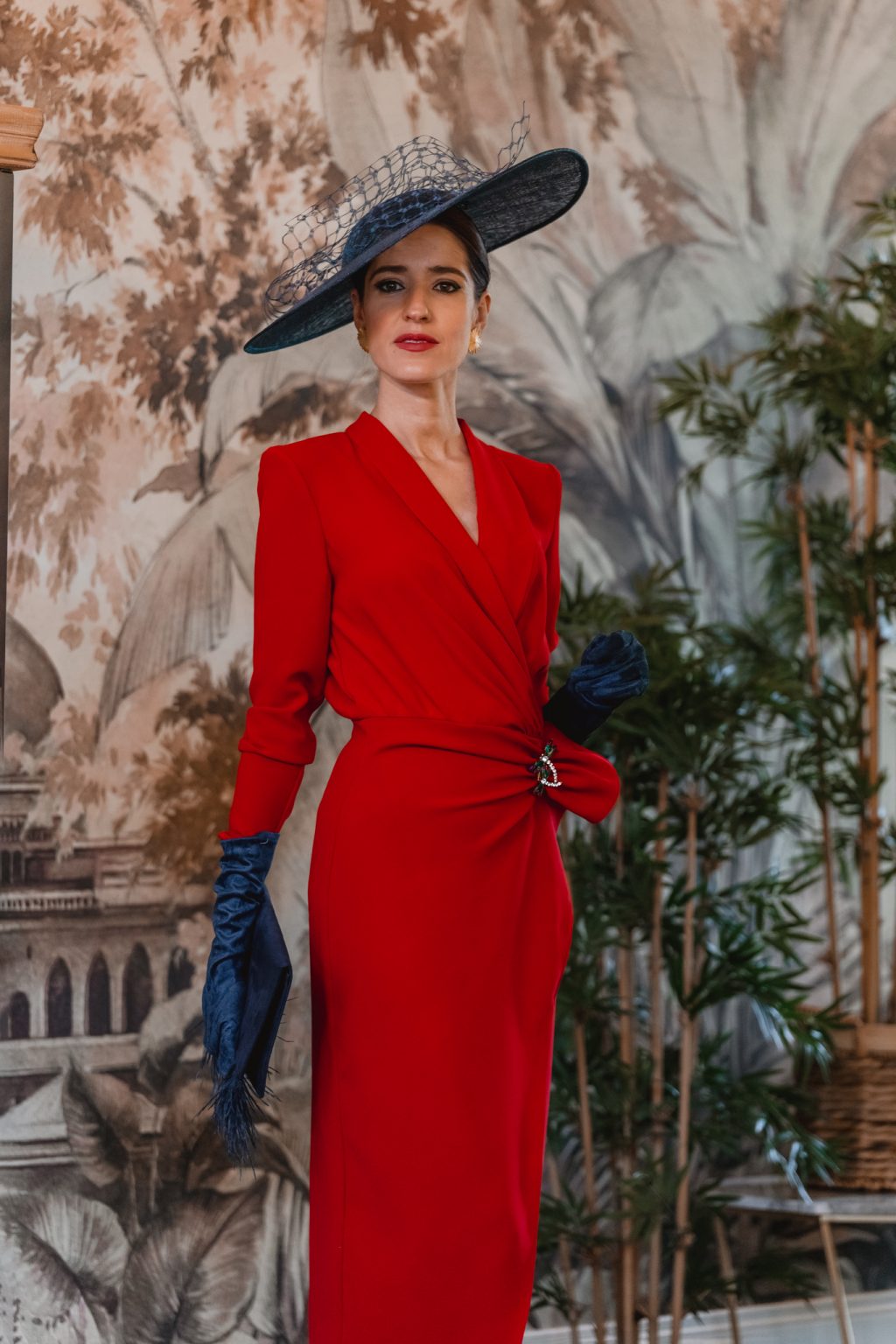 Invitada de boda en otoño e invierno con vestido rojo y pamela