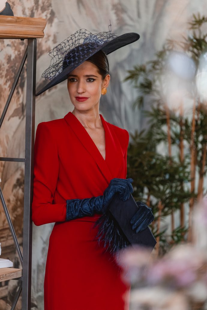 Invitada de boda en otoño e invierno con vestido rojo y pamela