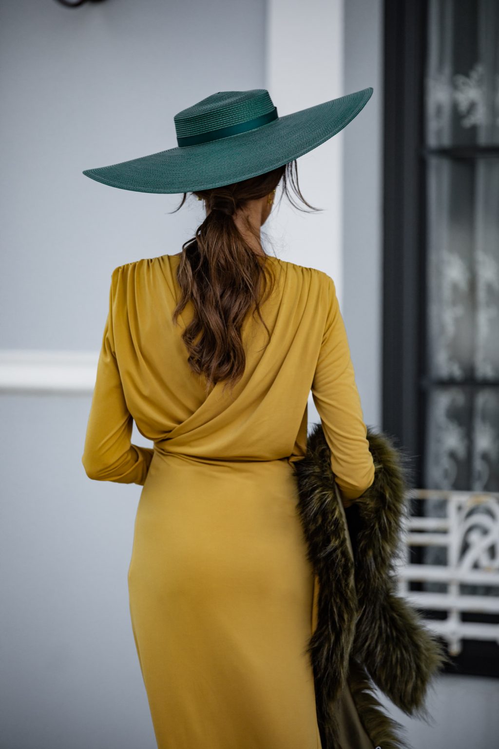 Vestido mostaza de invitada con pamela para bodas de invierno